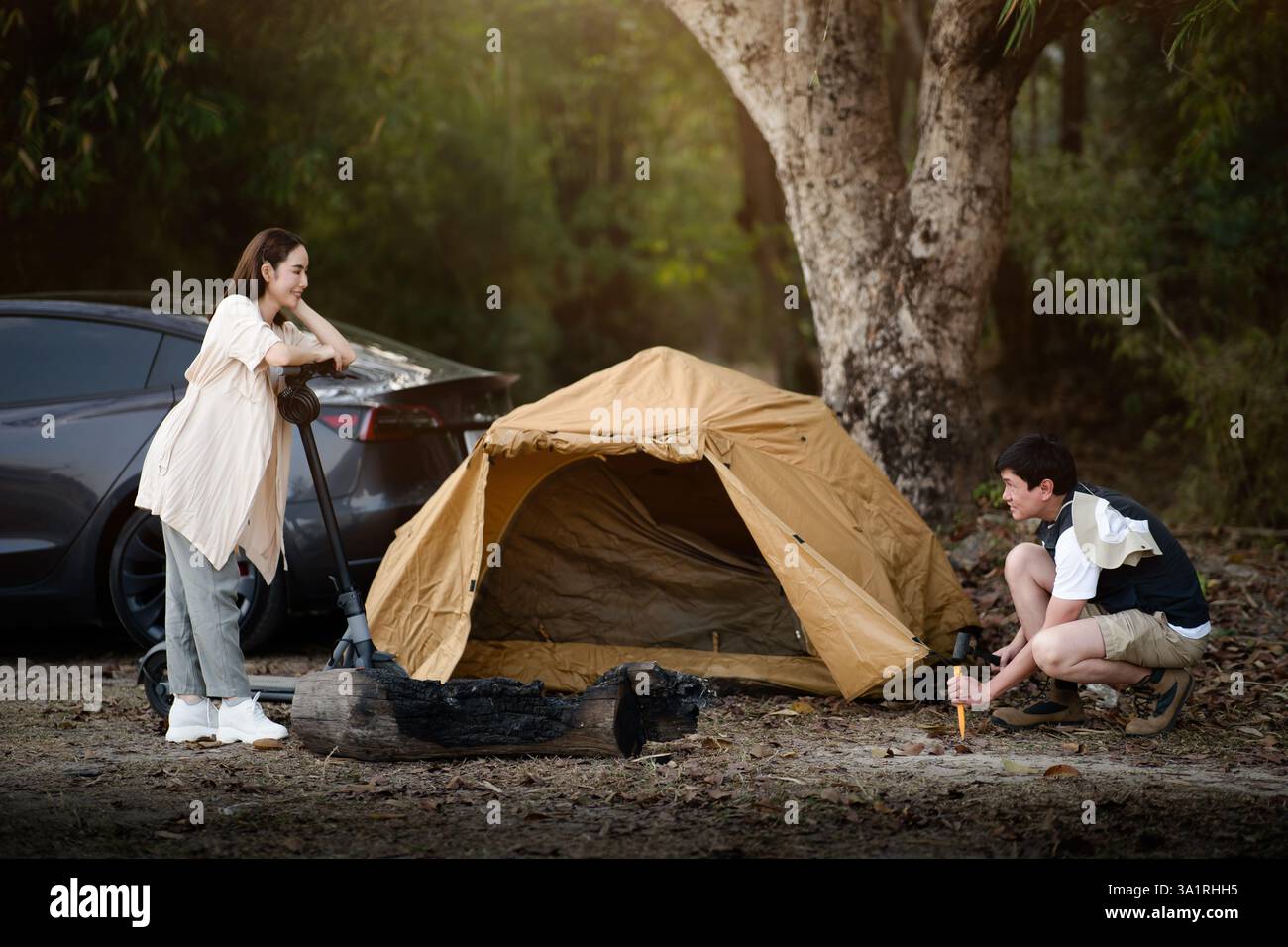 The woman is holding a scooter while smiling to the man setting up ...