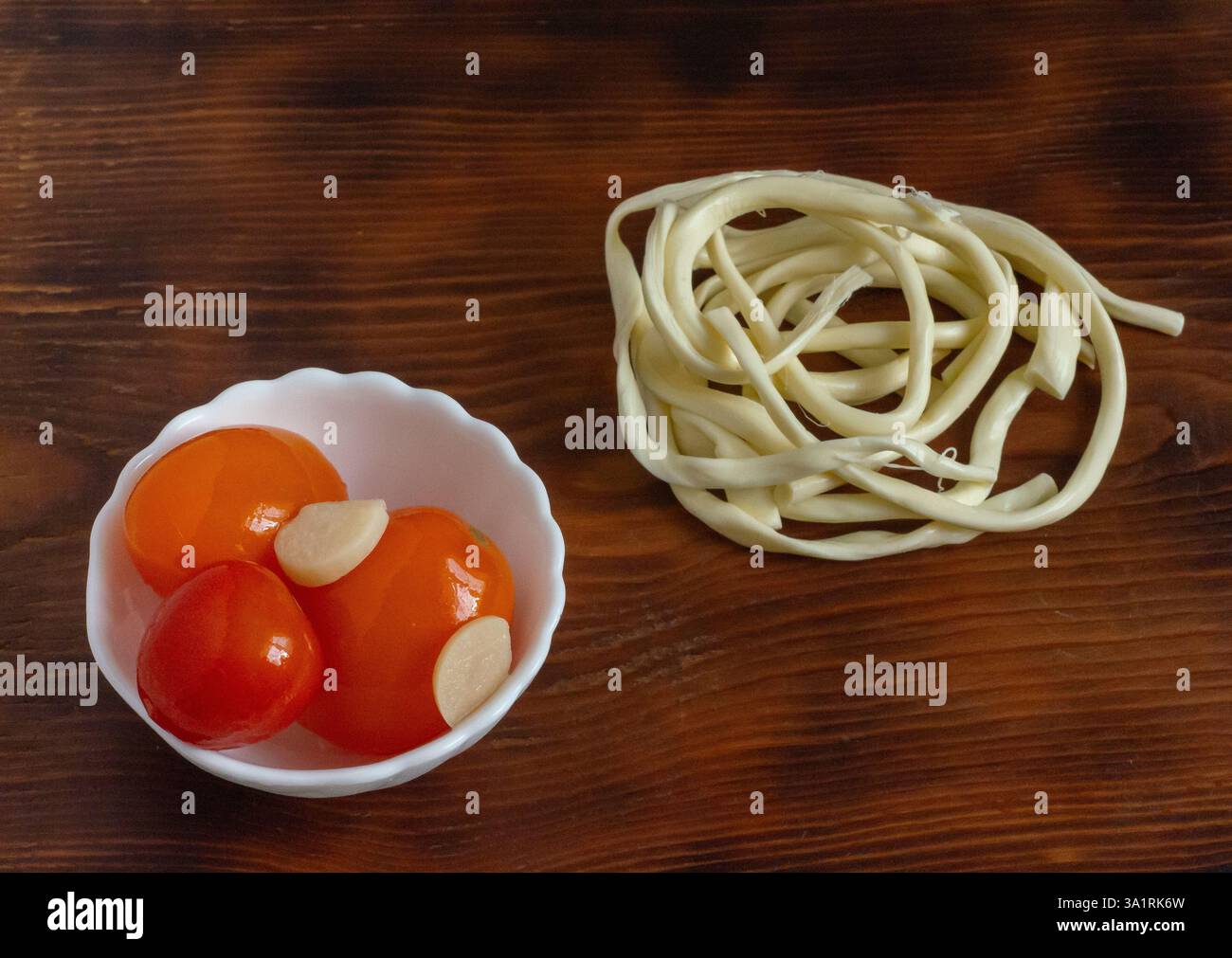Orange cherry tomato. cheese threads on a mahogany stand Stock Photo ...