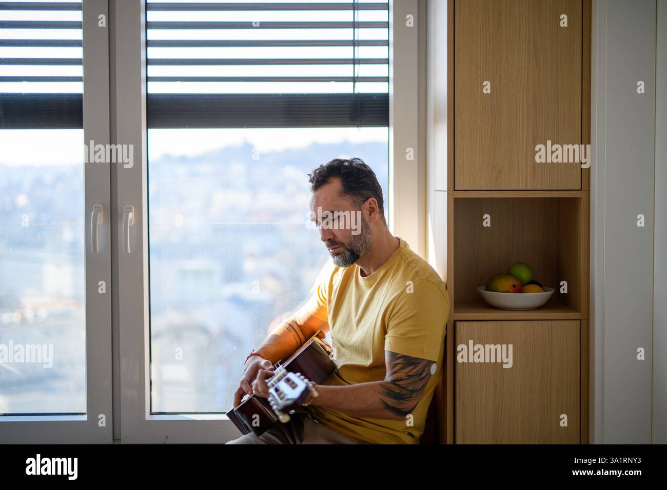 Diabetic man with CGM sensor on arm playing on guitar Stock Photo - Alamy