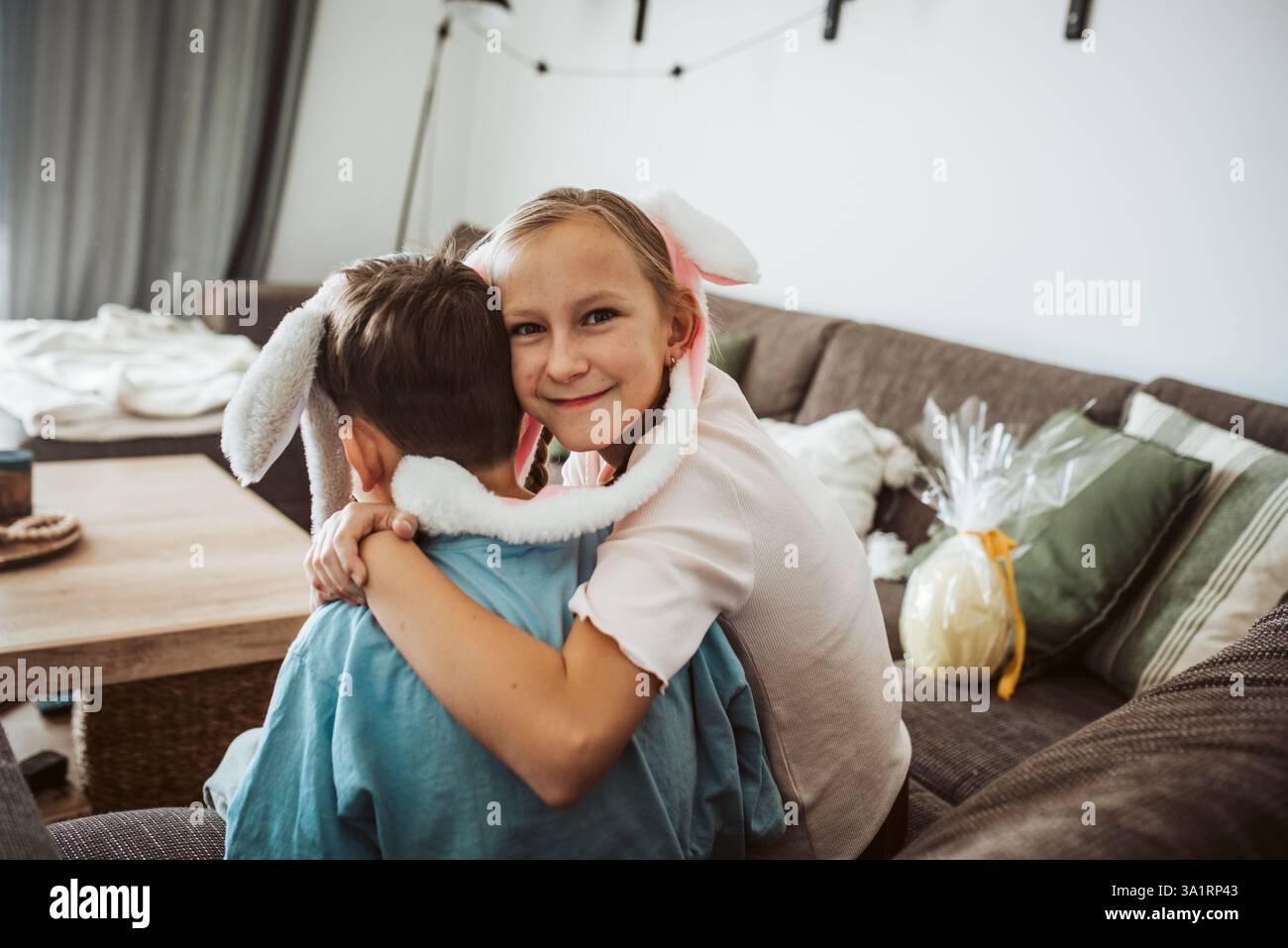 Brother and sister wearing bunny ears and hugging. Siblings celebrating ...