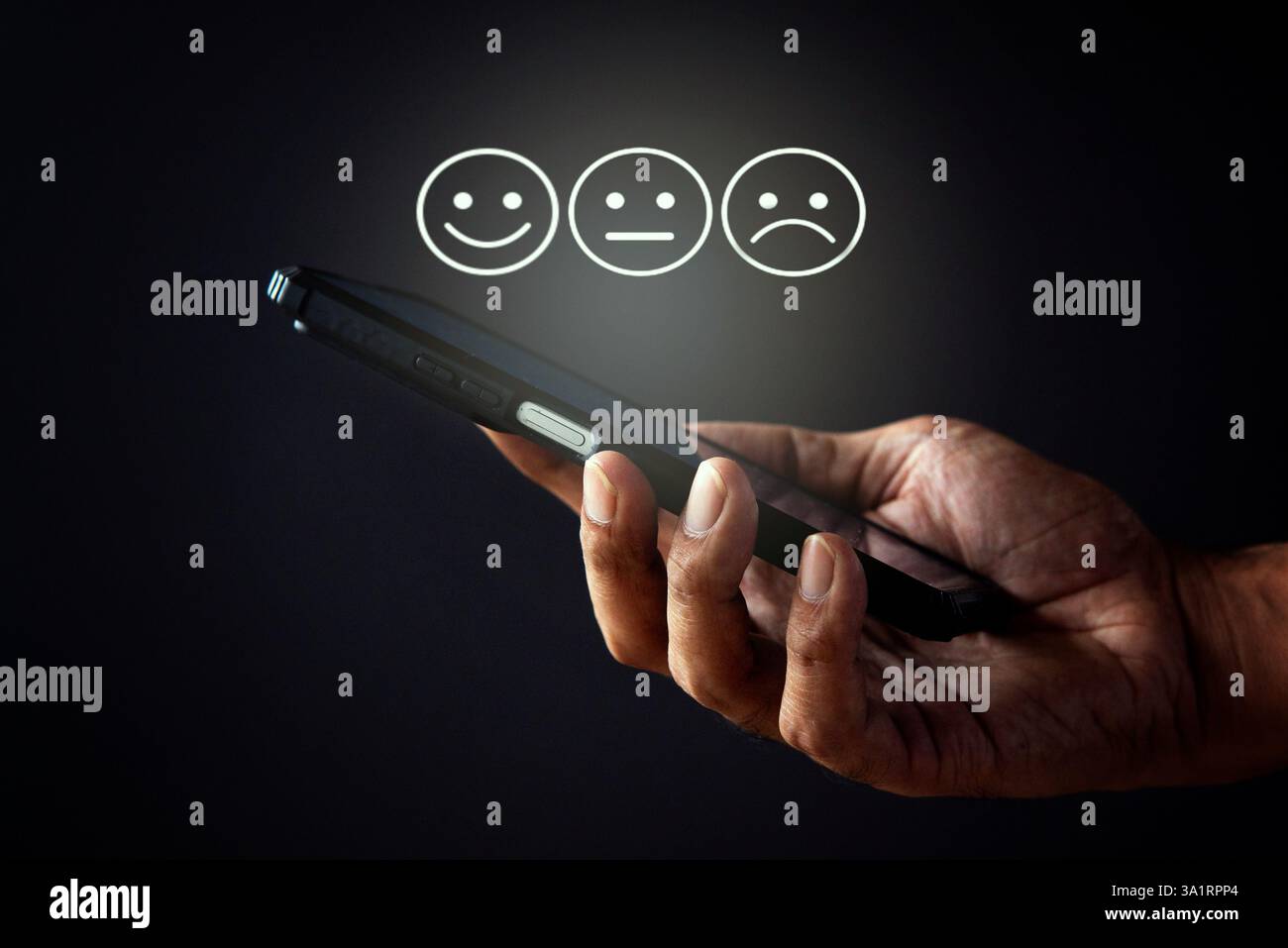A hand holding smartphone with three emoticon faces. Customer feedback ...