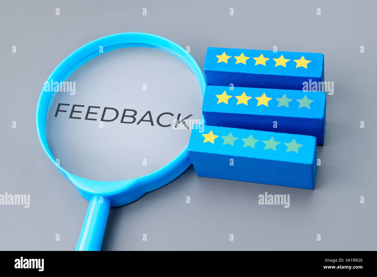 A magnifying glass with the word "FEEDBACK" next to three blue blocks ...