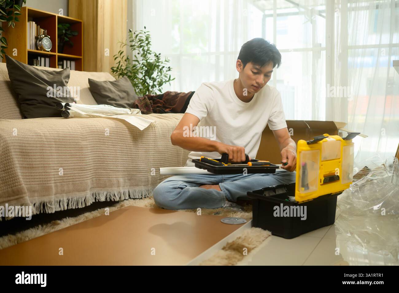 Young asian man checking the assembly guide before for new furniture ...