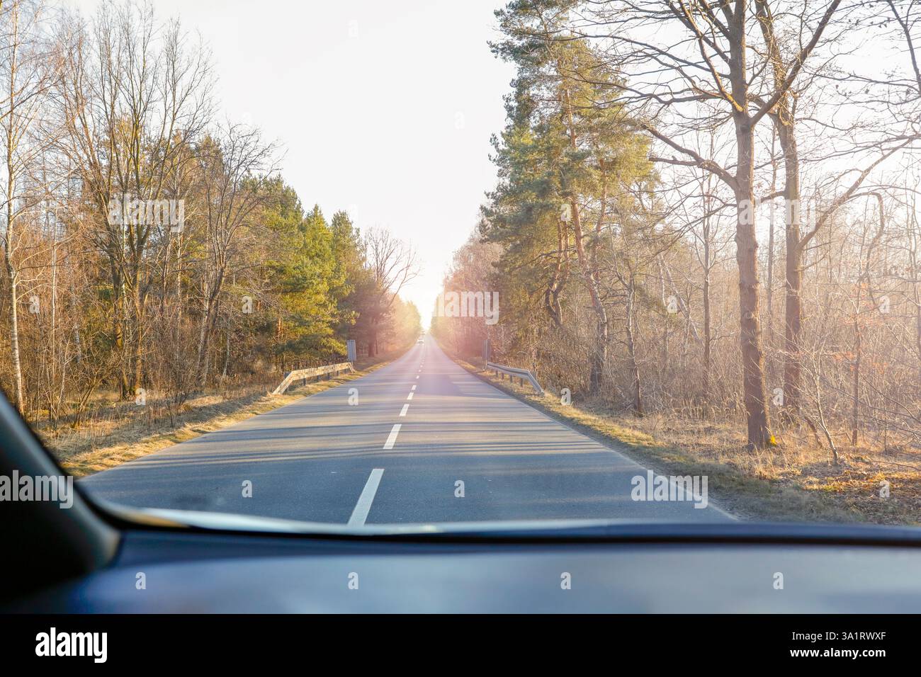 View from a car's dashboard through the windshield, showing a long ...