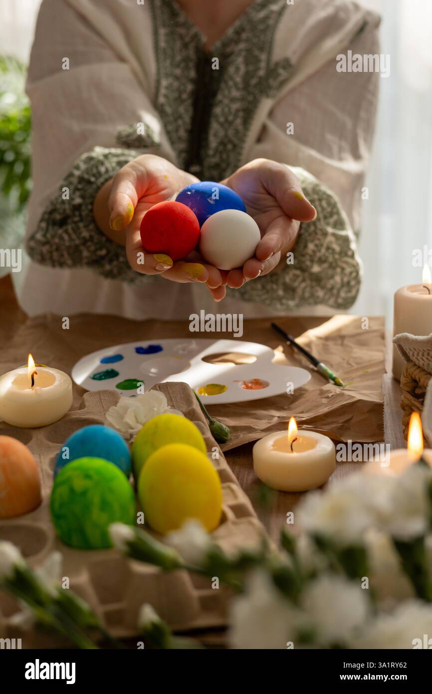 Woman in Traditional clothes holds three painted Easter eggs in red ...