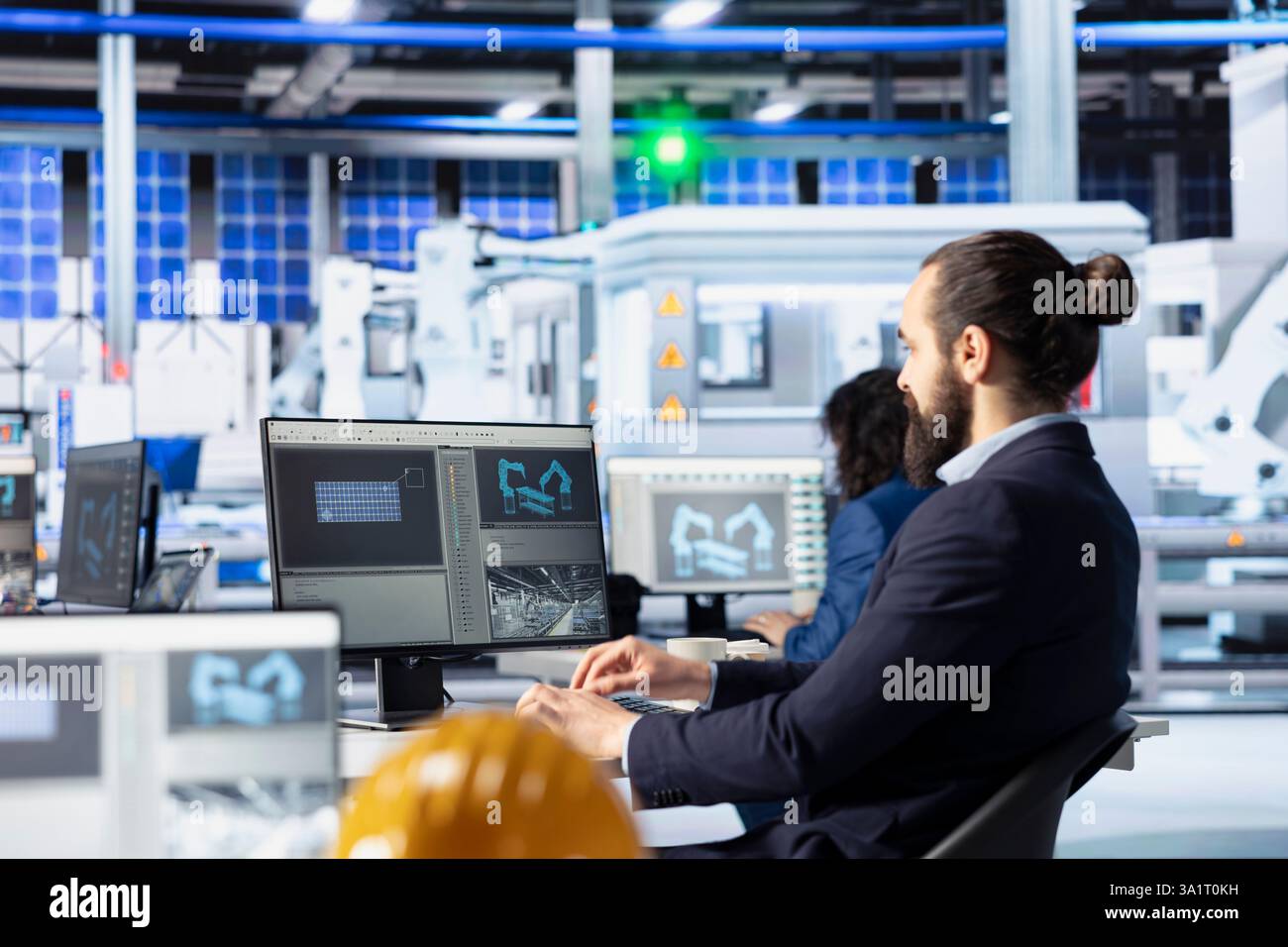 Engineer in solar panel manufacturing facility reviewing photovoltaic ...