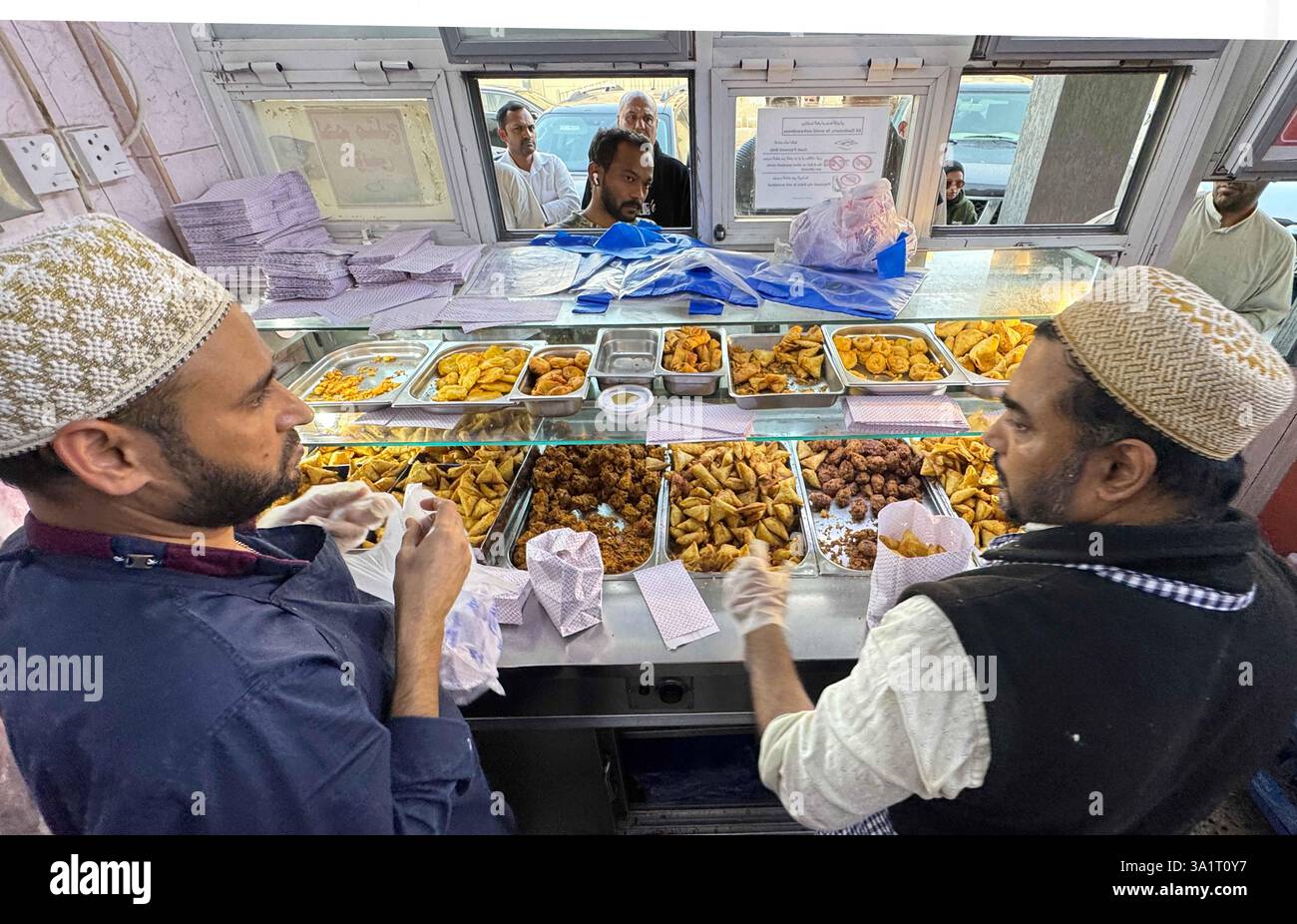 Hawalli, Kuwait. 9th Mar, 2025. People buy traditional foods at a ...