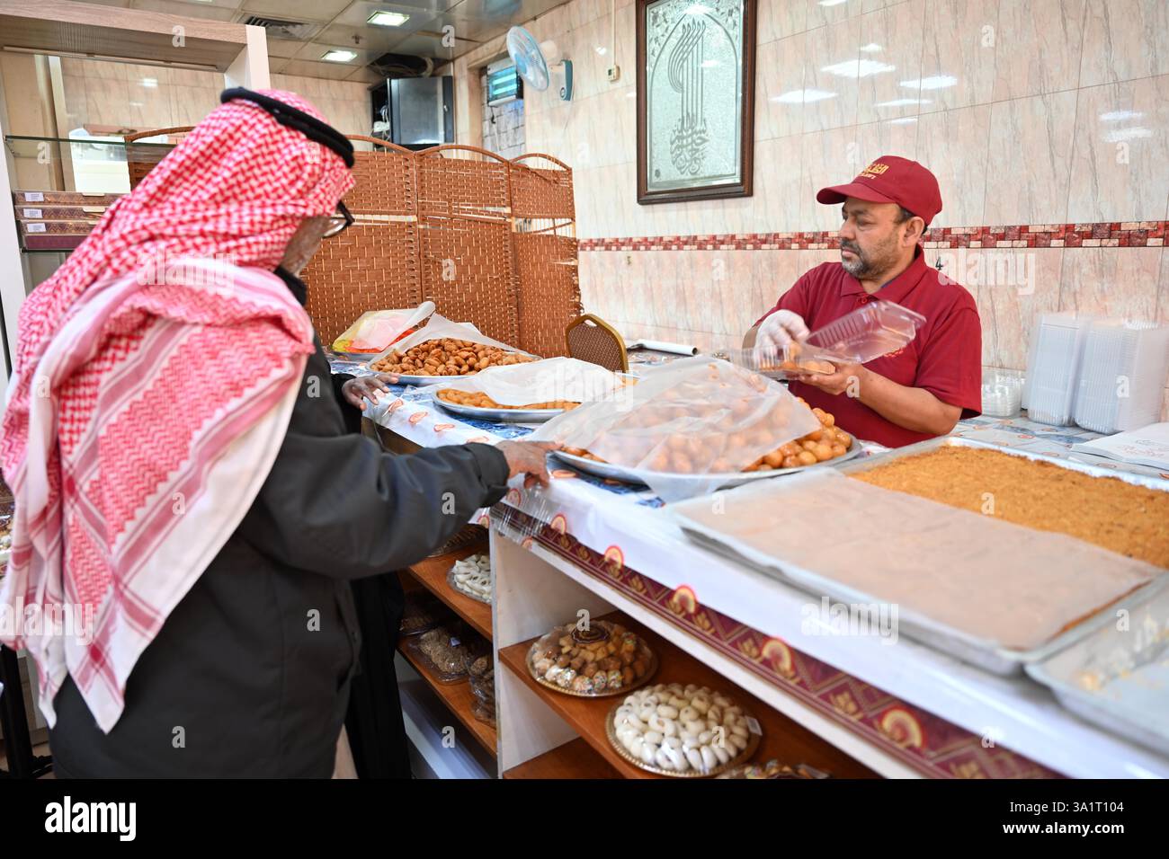 (250310) -- HAWALLI, March 10, 2025 (Xinhua) -- A man (L) buys ...