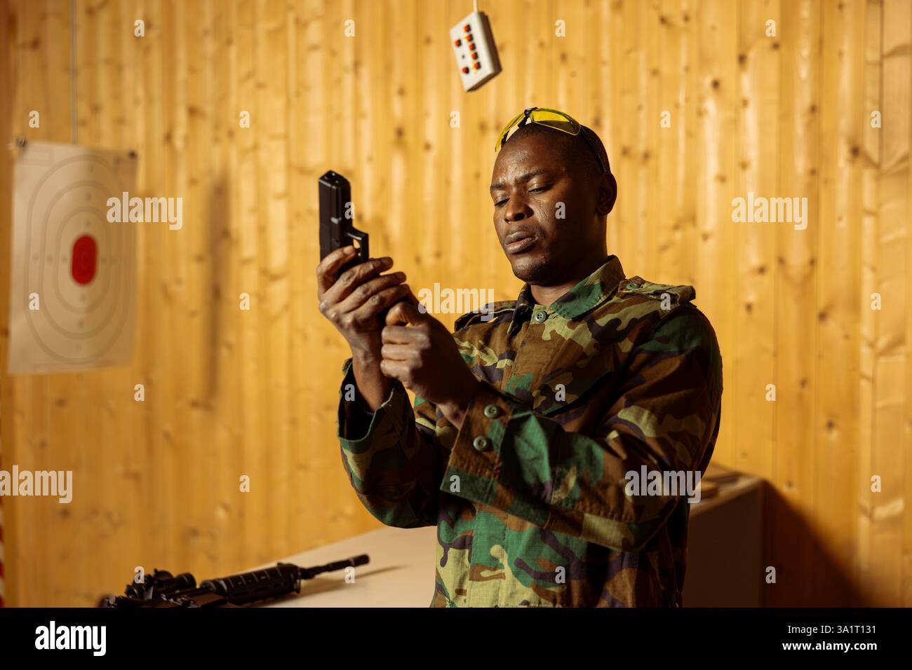 Army soldier in shooting range reloading pistol, preparing to shoot ...