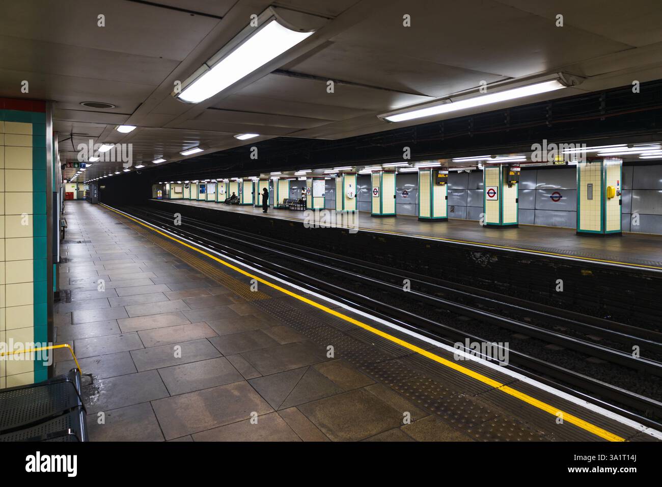 Underground train station with a long empty platform and waiting area ...