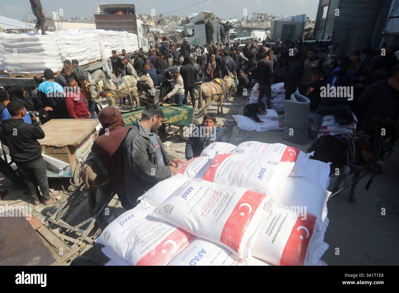 Gaza. 9th Mar, 2025. Palestinians receive wheat flour packages as ...