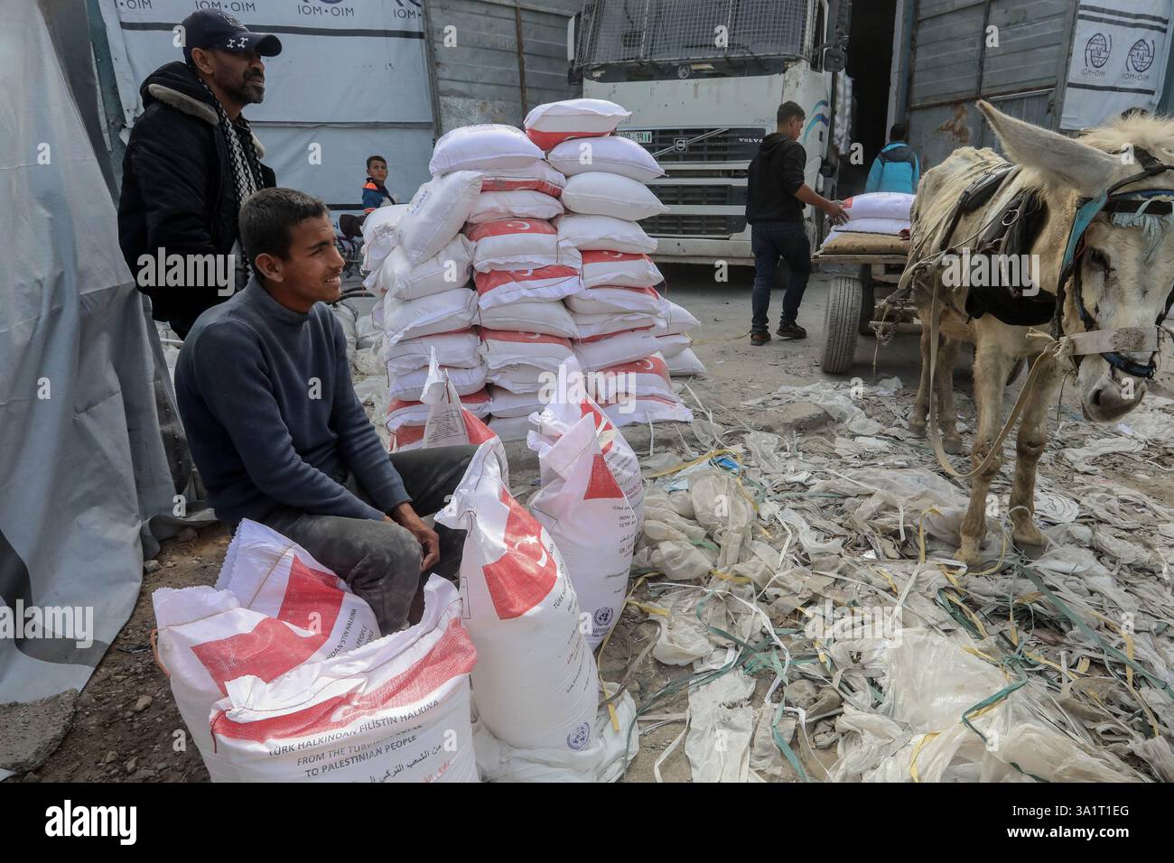 Gaza. 9th Mar, 2025. Palestinians receive wheat flour packages as ...