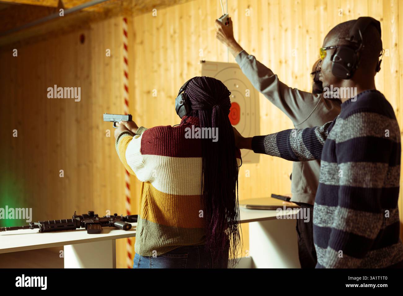 Shooting range expert supervising facility while customers use weapons ...