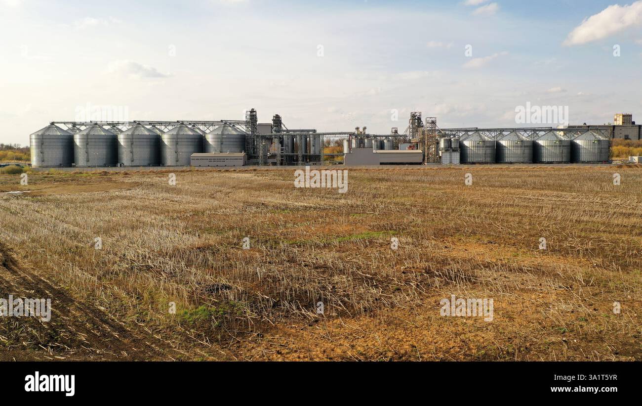 Large metal grain silos storing harvested crops in a vast agricultural ...