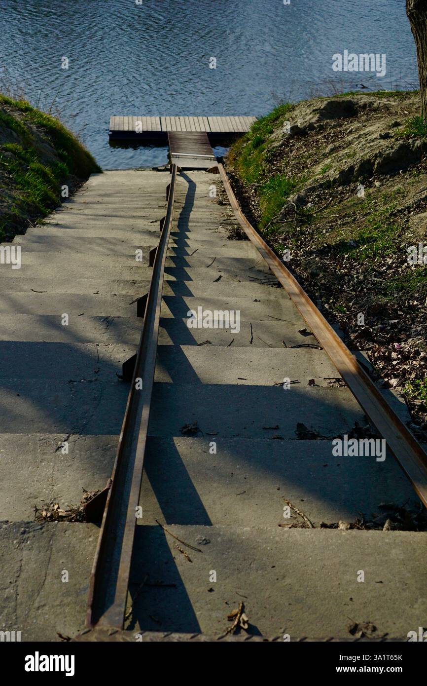 Metal rails leading down stairs to water for boat and kayak launch ...