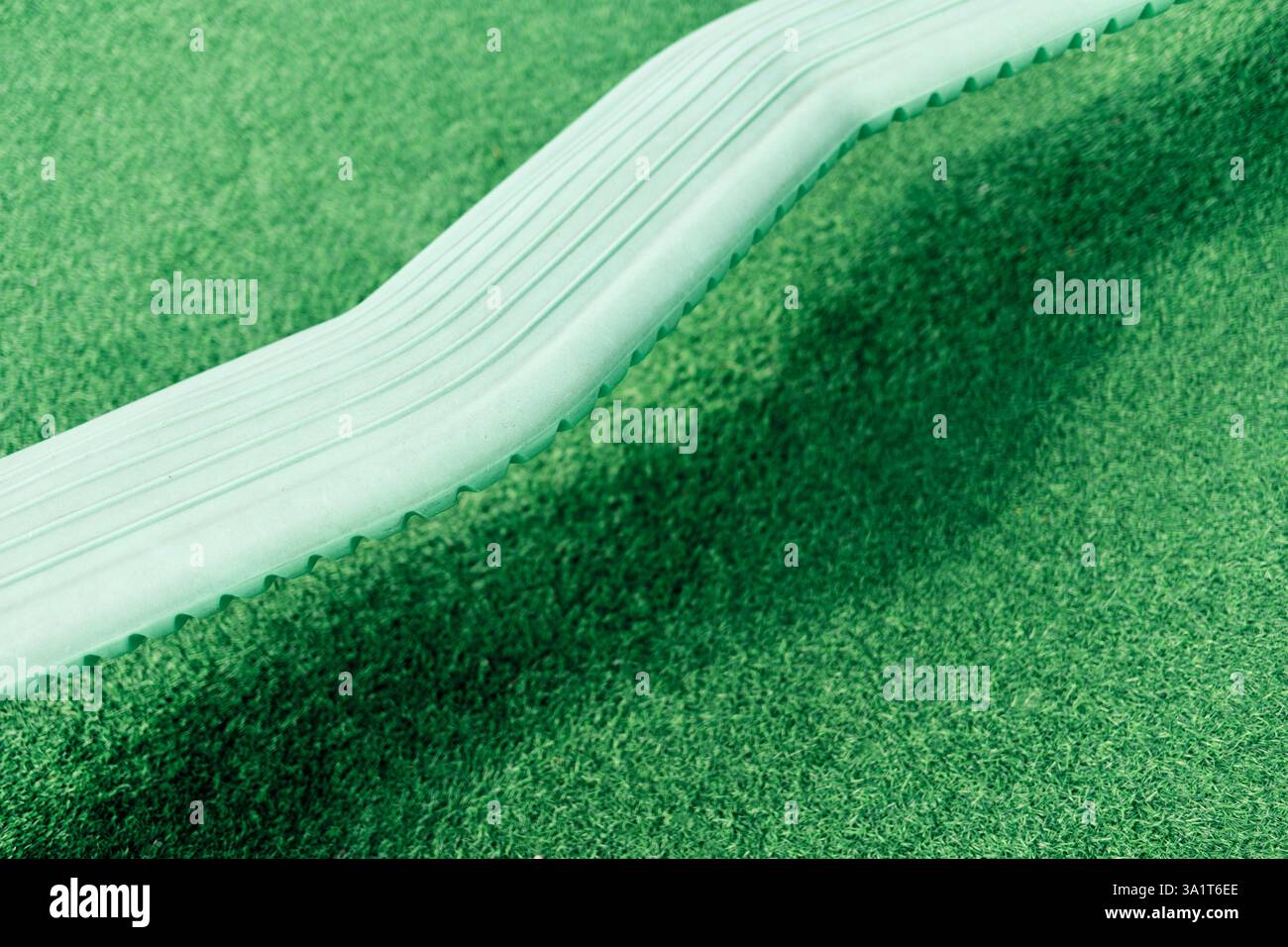 Balancing beam resting on green artificial turf in playground setting ...