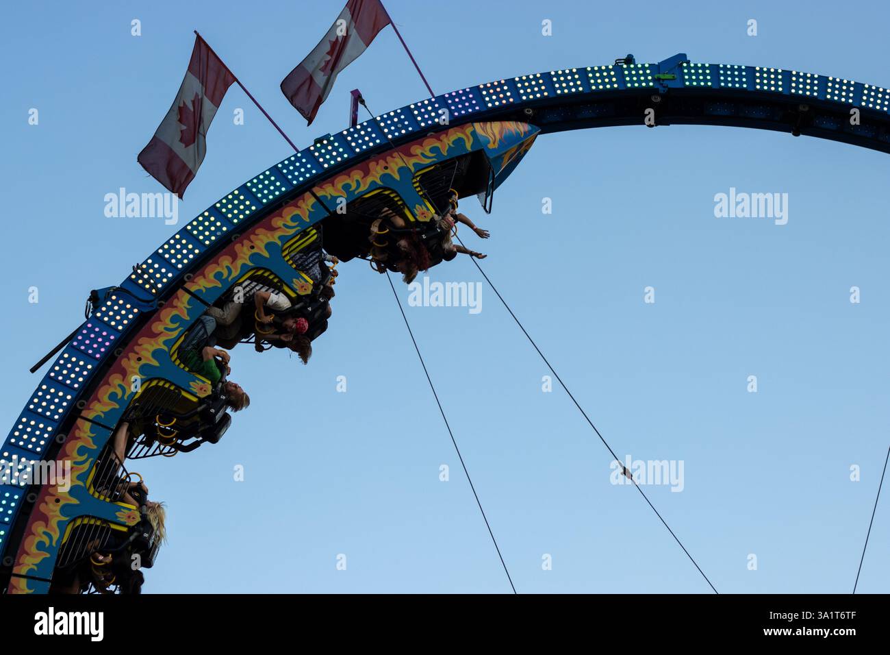 Riders upside down on an exciting midway ride with Canadian flags Stock ...
