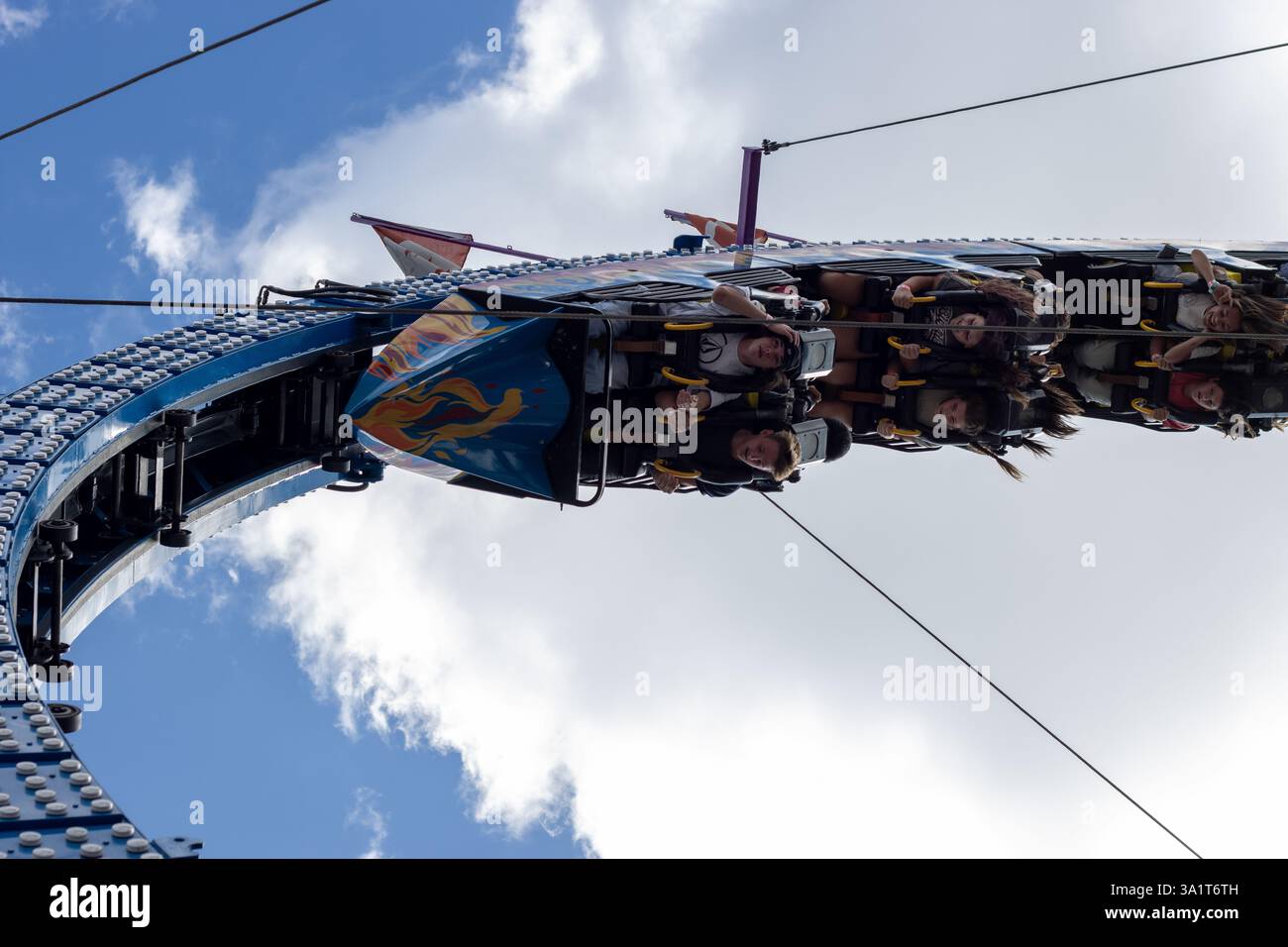 Riders experience thrills on an upside-down midway amusement ride Stock ...