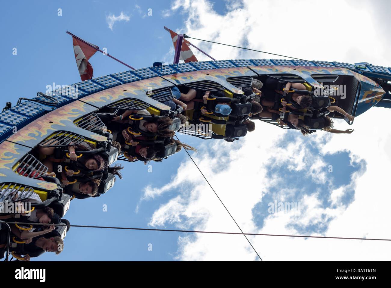Riders experience thrills on an upside-down midway amusement ride Stock ...