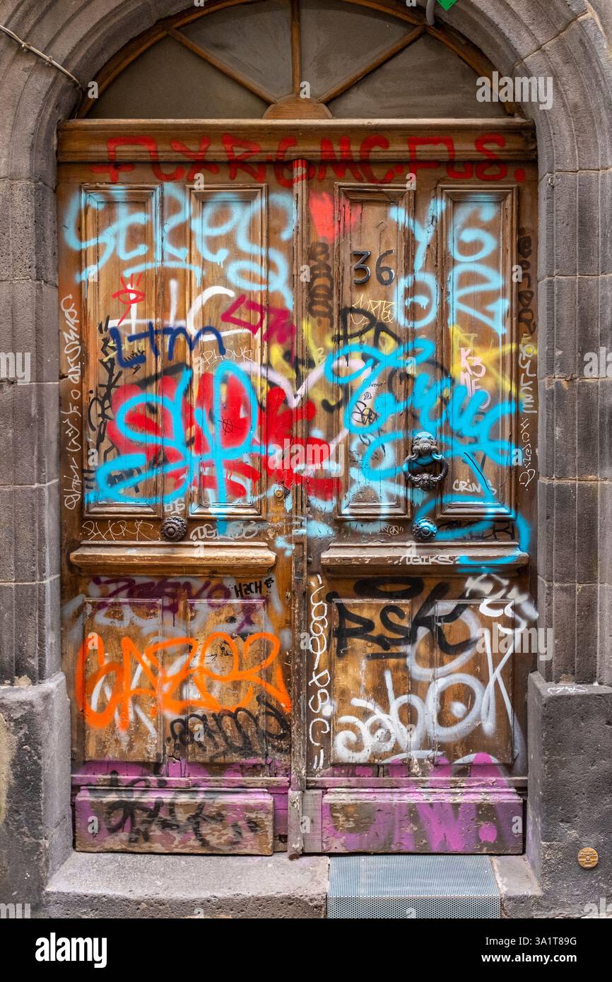 Graffiti on bigh wooden door of building, Clermont Ferrand, Auvergne ...