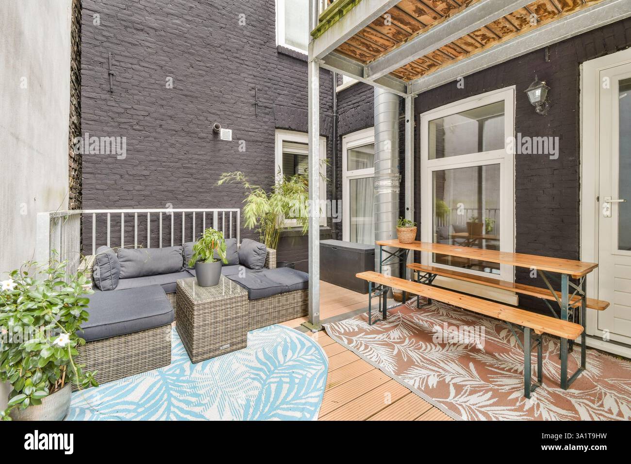 A stylish urban patio featuring a cozy seating area, greenery, and a ...