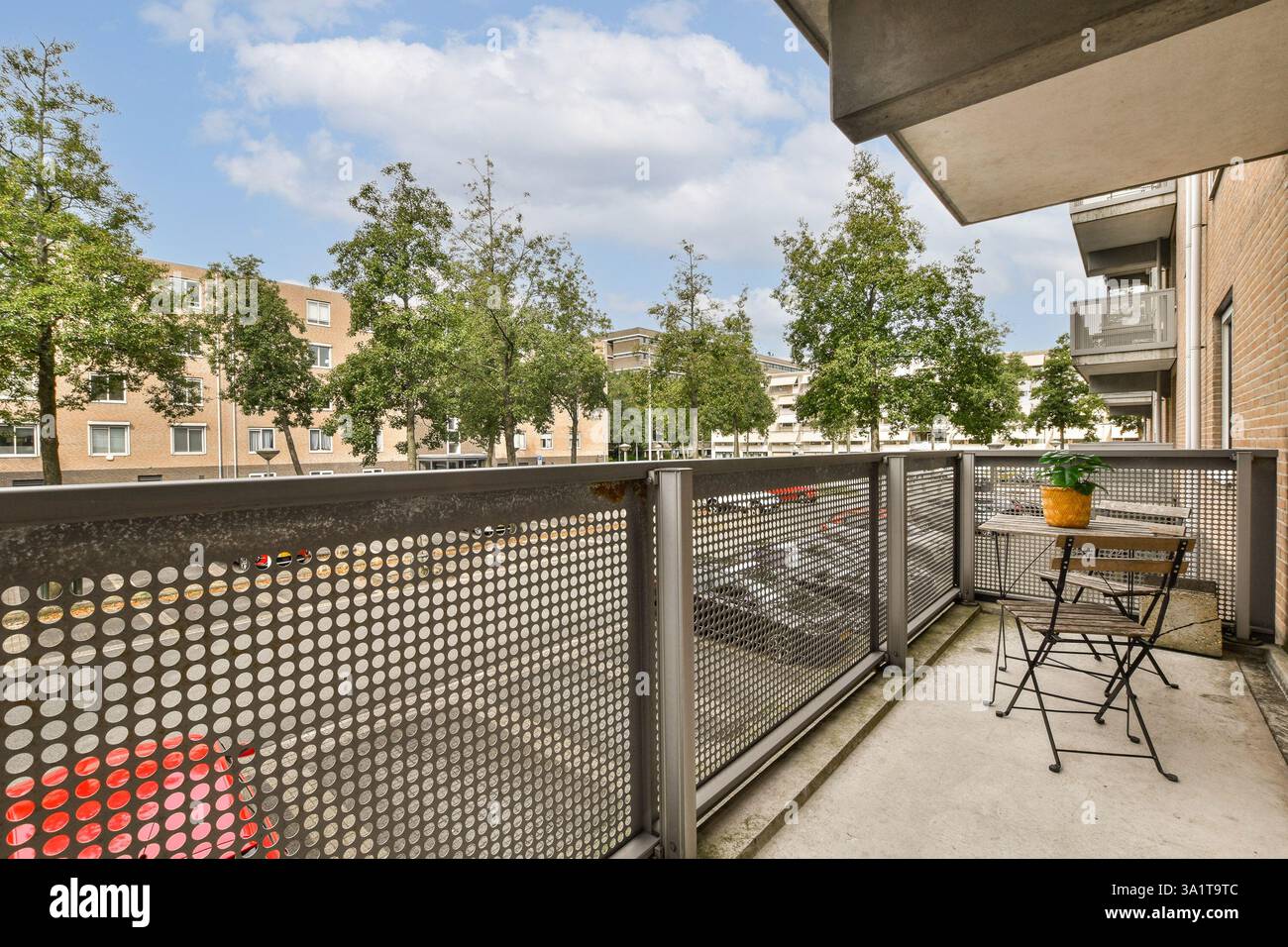 A contemporary balcony view featuring green trees lining the street ...