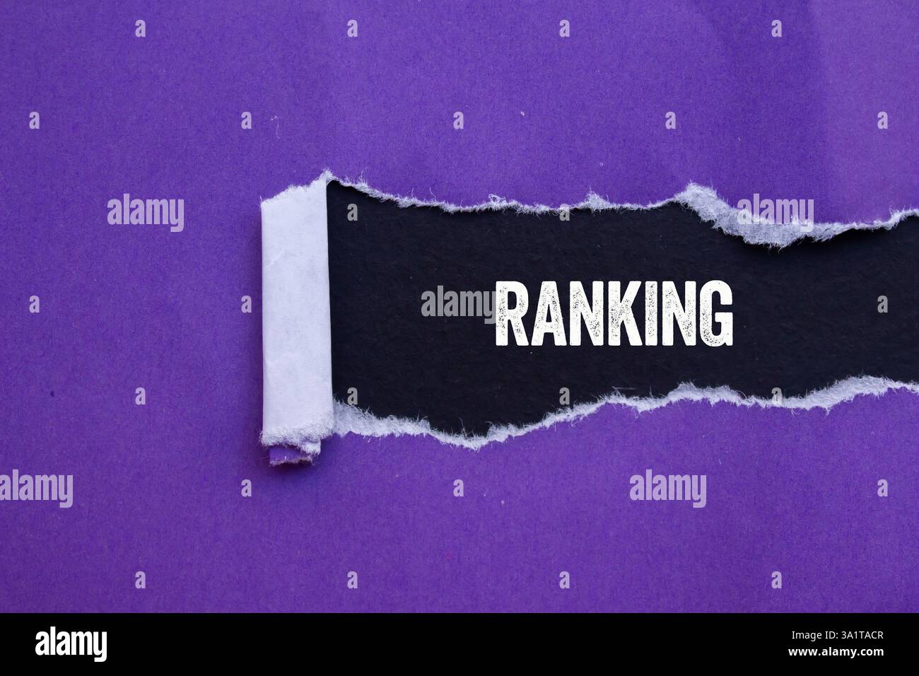 Ranking message written on ripped torn purple paper on black background ...