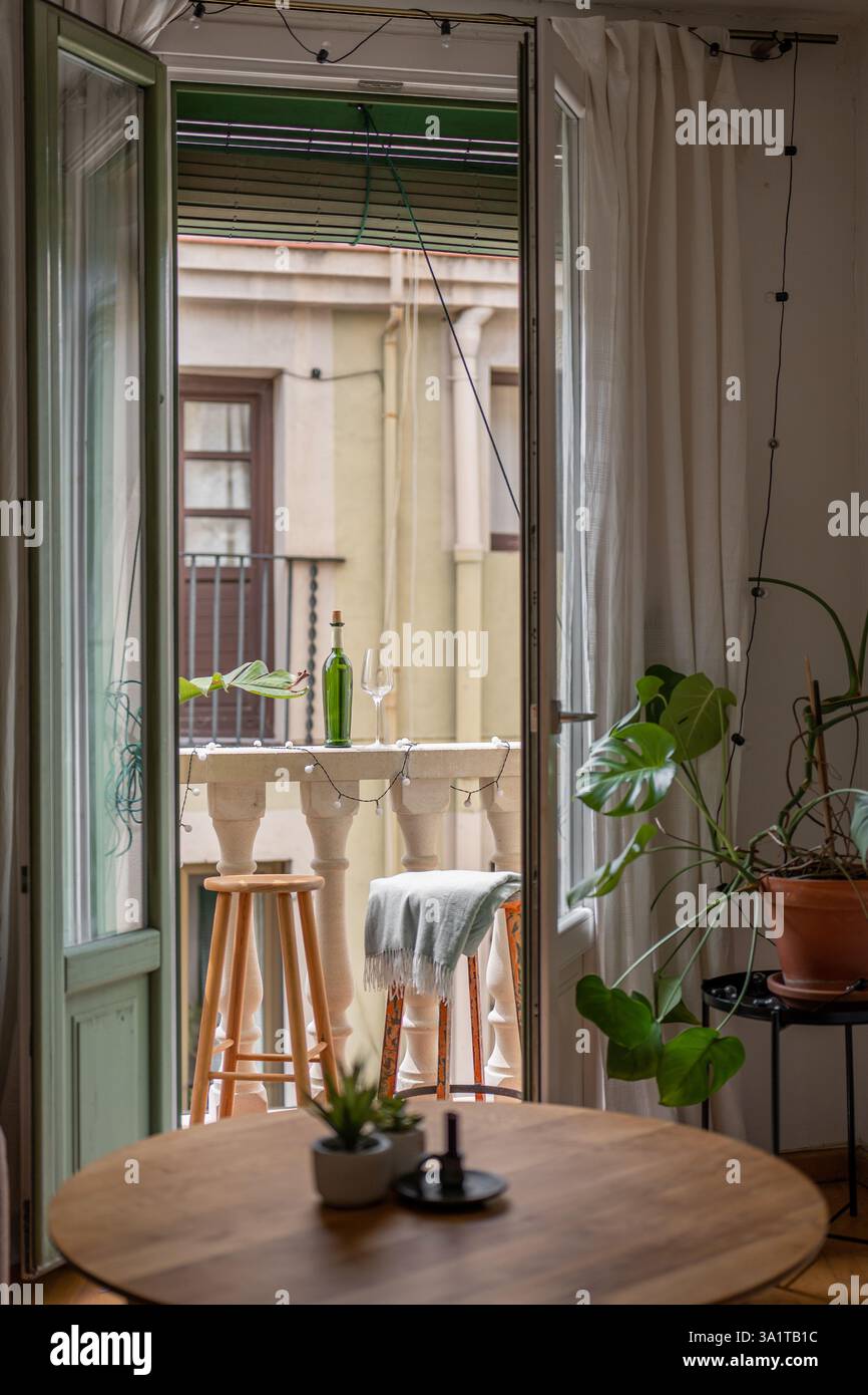 Inviting small balcony setup with stools, a table, and a wine bottle ...