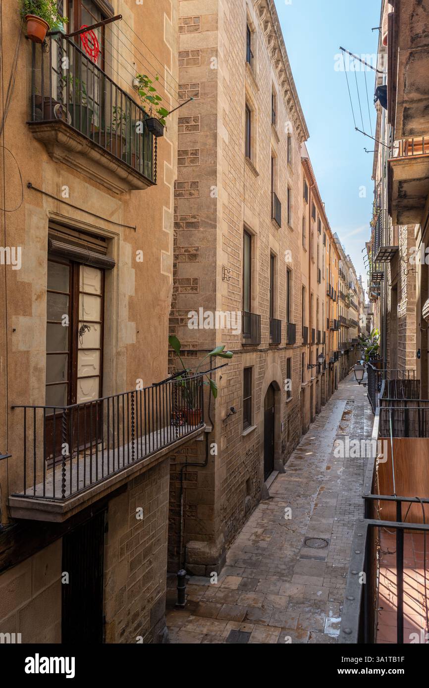 Narrow cobbled alleyway with historic stone facades and small balconies ...