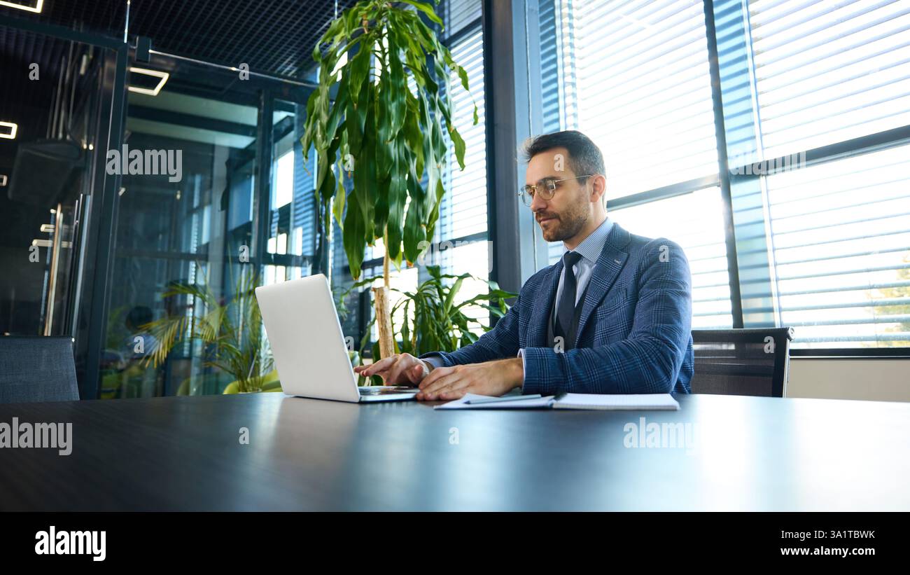Confident businessman typing on laptop, making important business ...