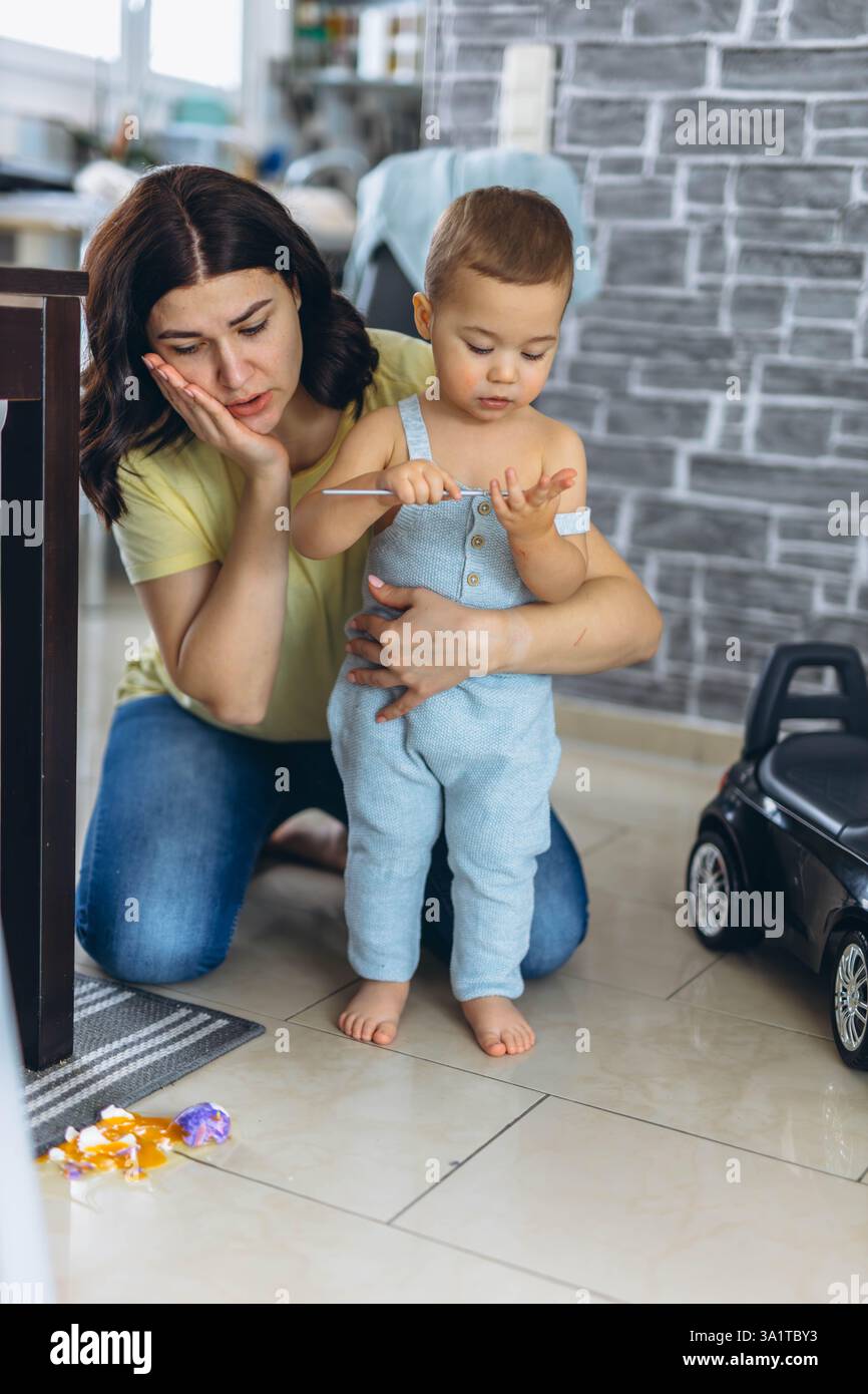 Angry mother scolding her son for breaking an egg in the kitchen ...