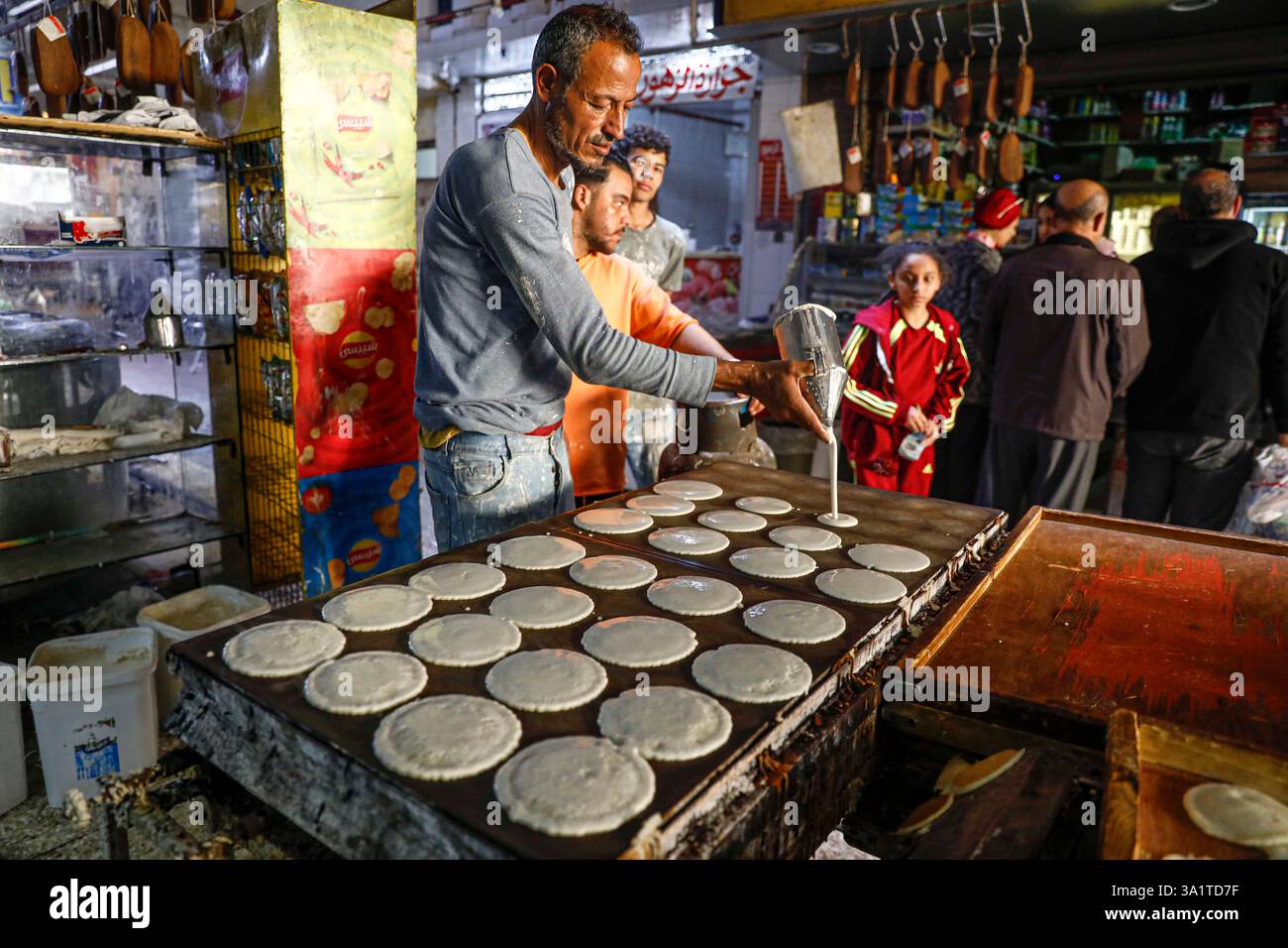 Cairo, Egypt. 9th Mar, 2025. A baker makes traditional sweets known as ...