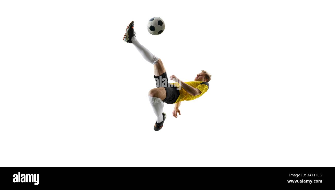 Focused man, soccer player executing overhead kick, dynamically kicking ball in air and falling ...