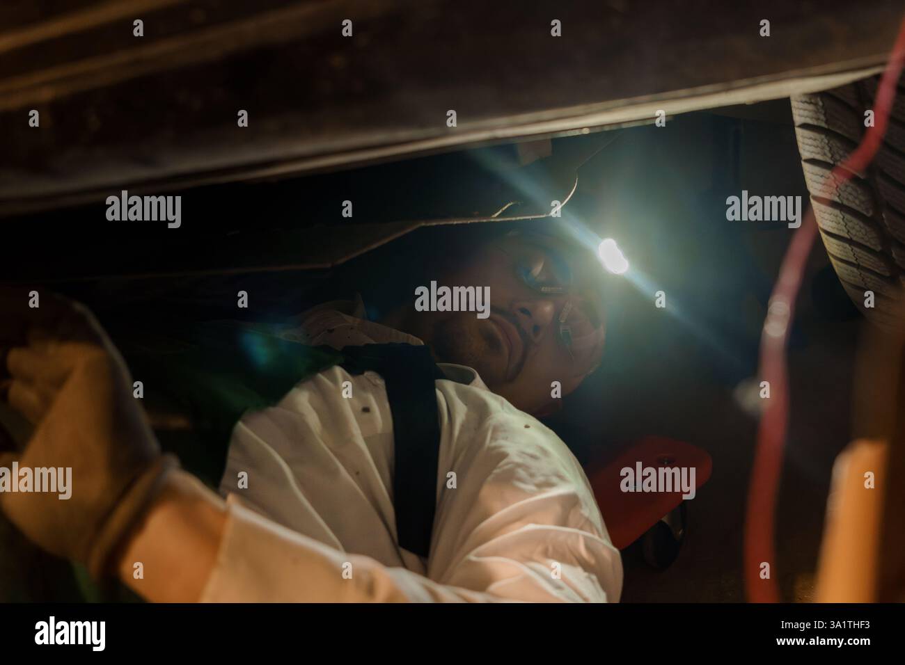 Mechanic in Gloves and Glasses Inspecting Vehicle Underneath Using ...