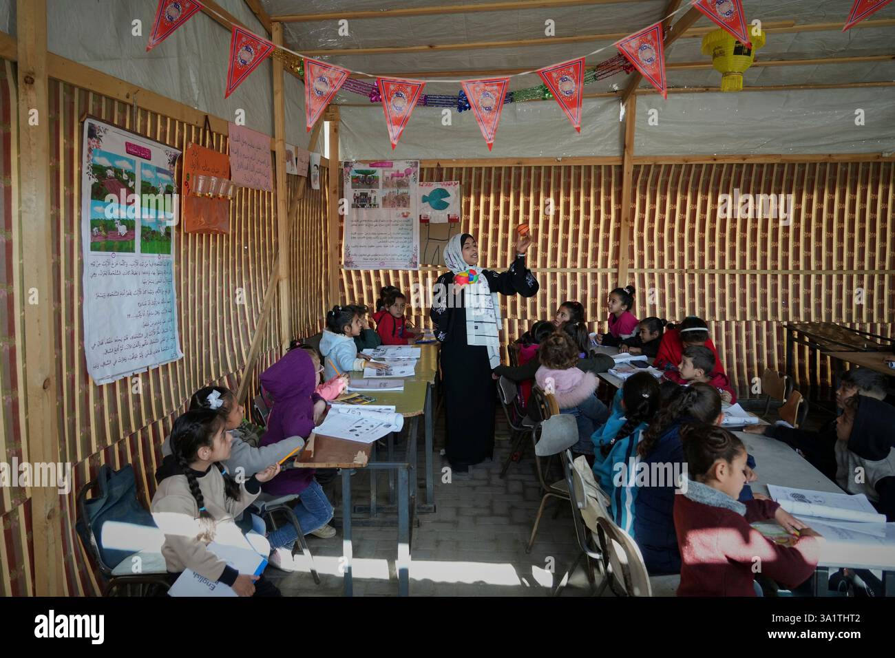 Palestinian children take a lesson in a makeshift classroom located ...