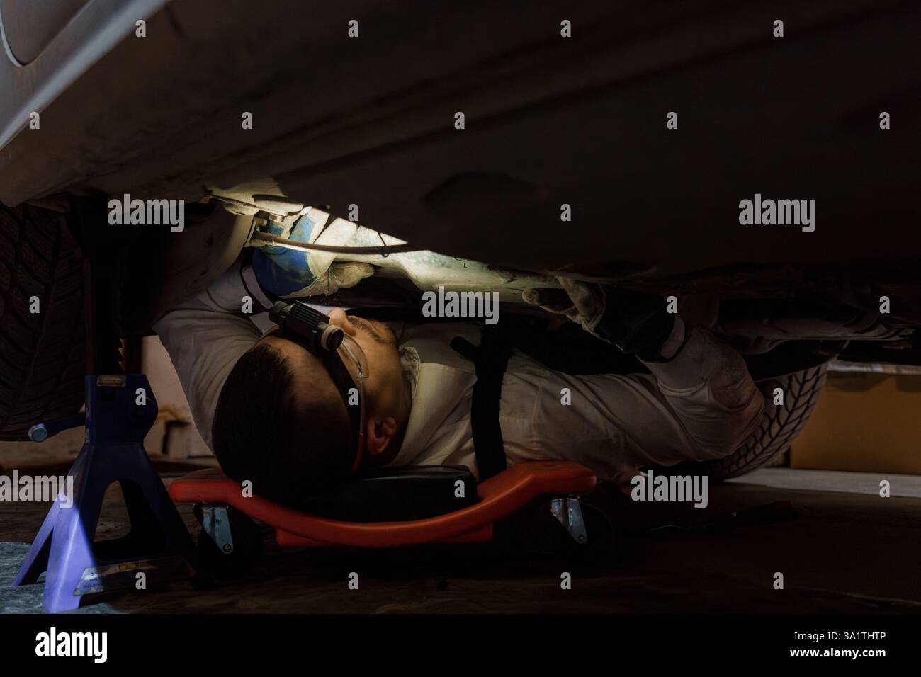 Professional Mechanic Inspecting Vehicle Underbody Using Flashlight in ...