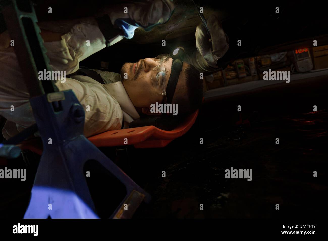 Close-up of Mechanic in Safety Gear Inspecting and Repairing Vehicle ...