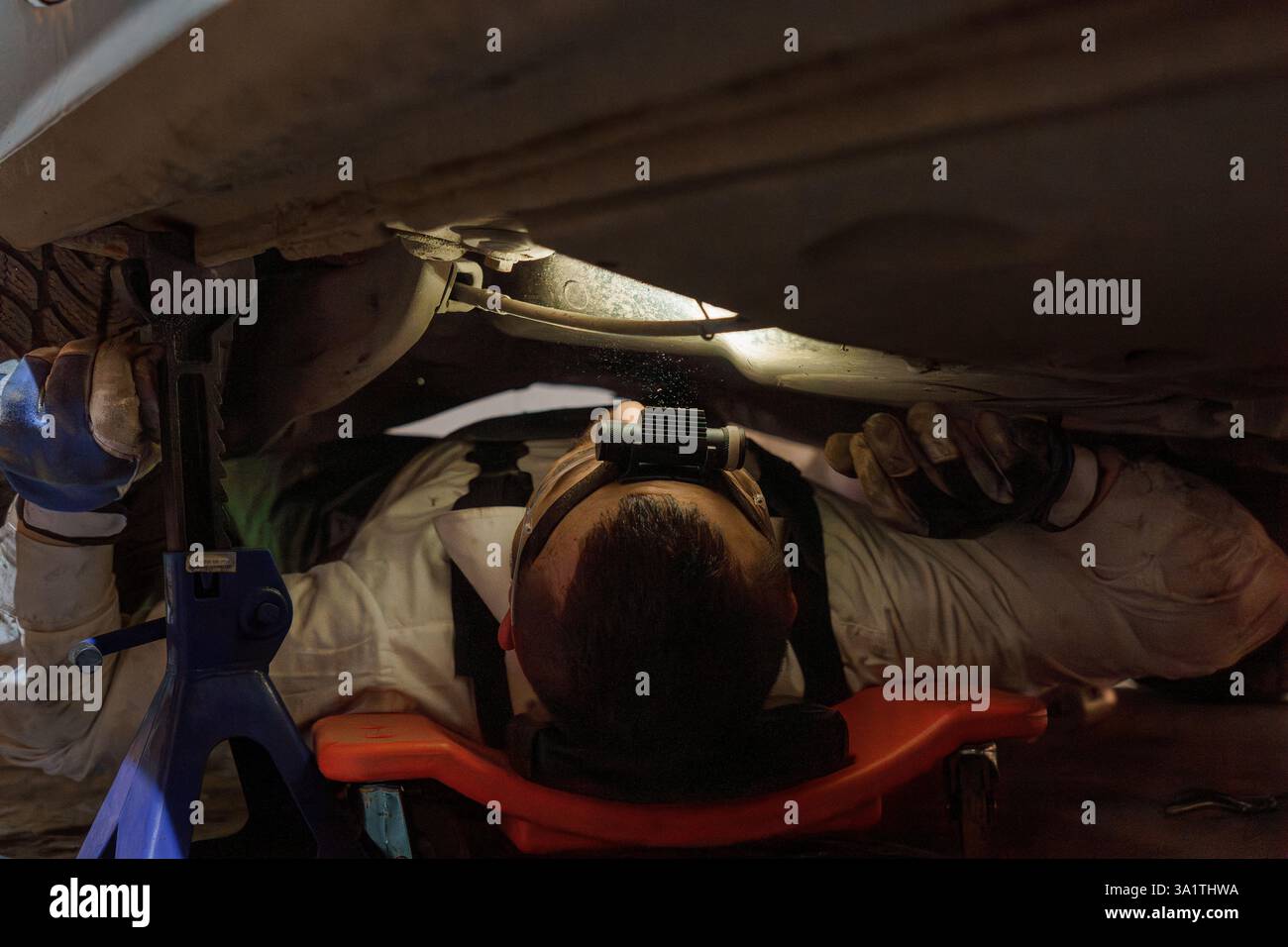 Mechanic Inspecting Vehicle Underneath Using Headlamp and Creeper in ...