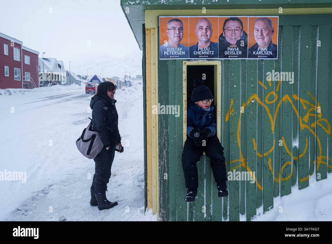A boy sits at the bus station with political placards for the upcoming ...