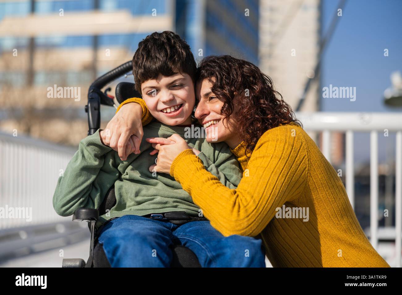 Mother hugging her son with disability in wheelchair outdoors Stock Photo - Alamy