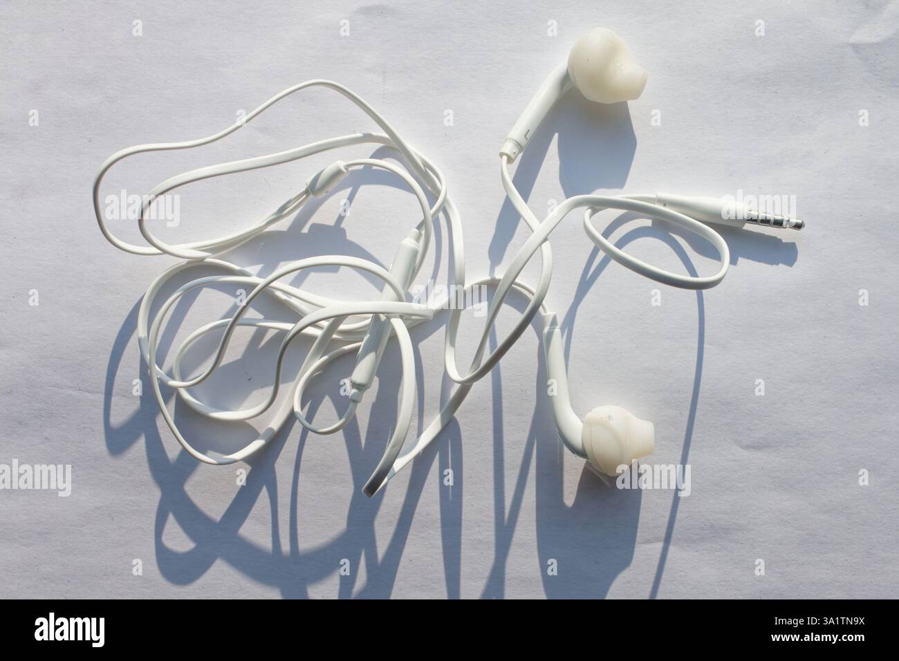 White wired headphones with tangled cable Stock Photo - Alamy