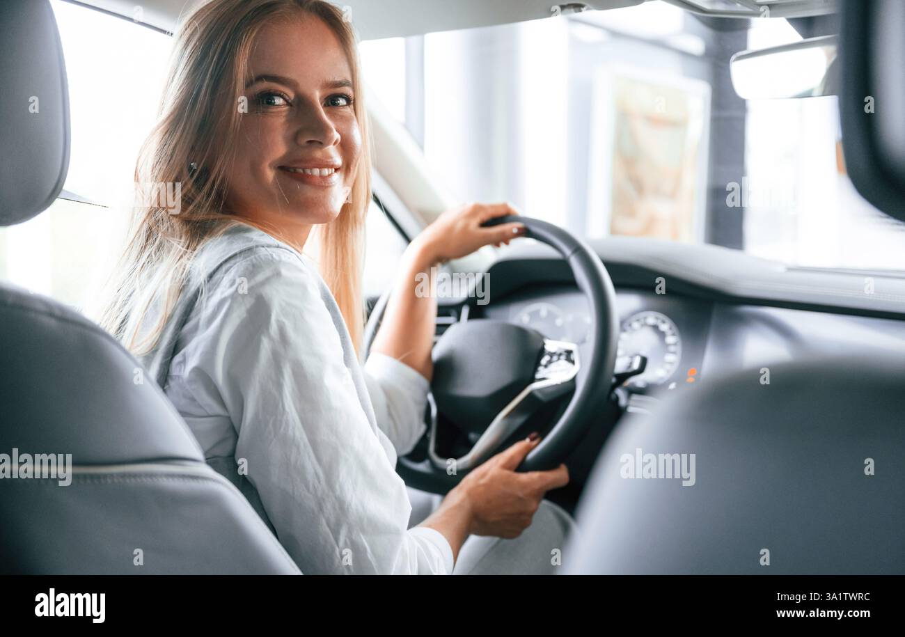 Modern quality interior. Woman is sitting in a car and driving it Stock ...