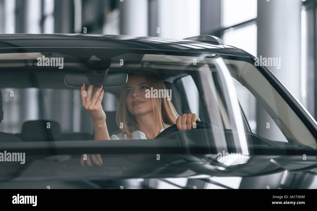 Front view, driving. Woman is sitting in a car Stock Photo - Alamy