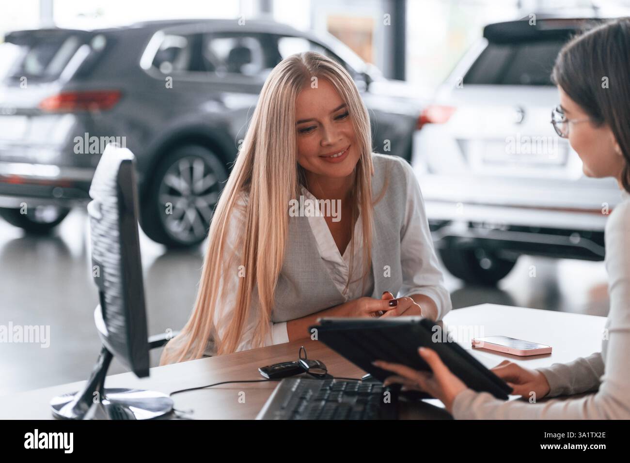 Sitting by the table. Female manager is helping woman customer in the ...
