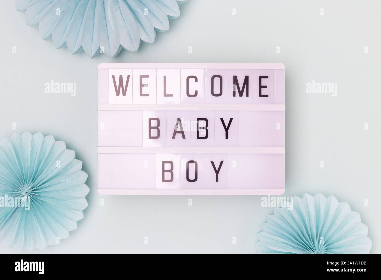 Welcome baby boy. Lightbox with letters and tissue paper fans in a blue ...