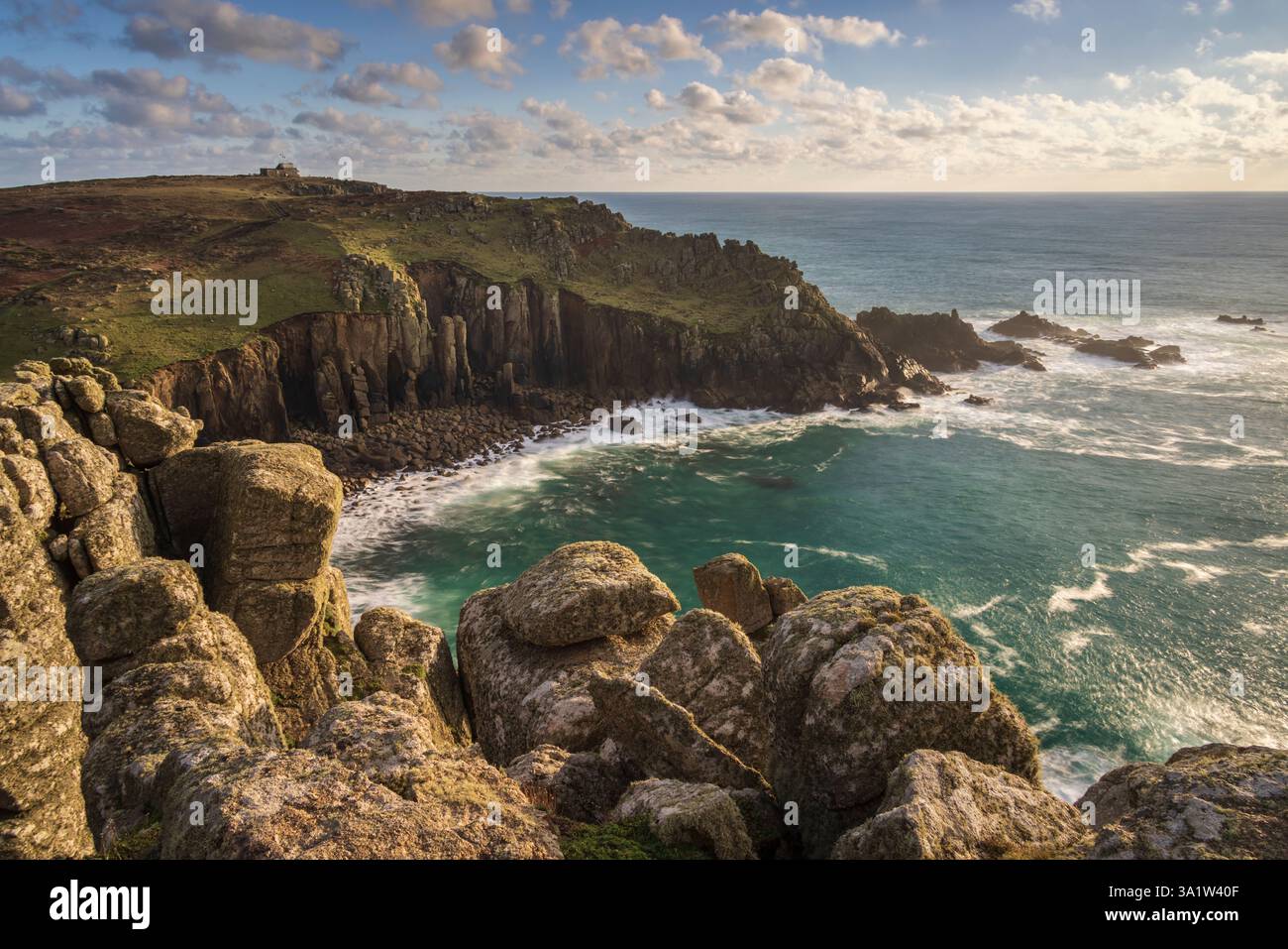 Sunny afternoon light on Porth Loe and the dramatic cliff tops of ...