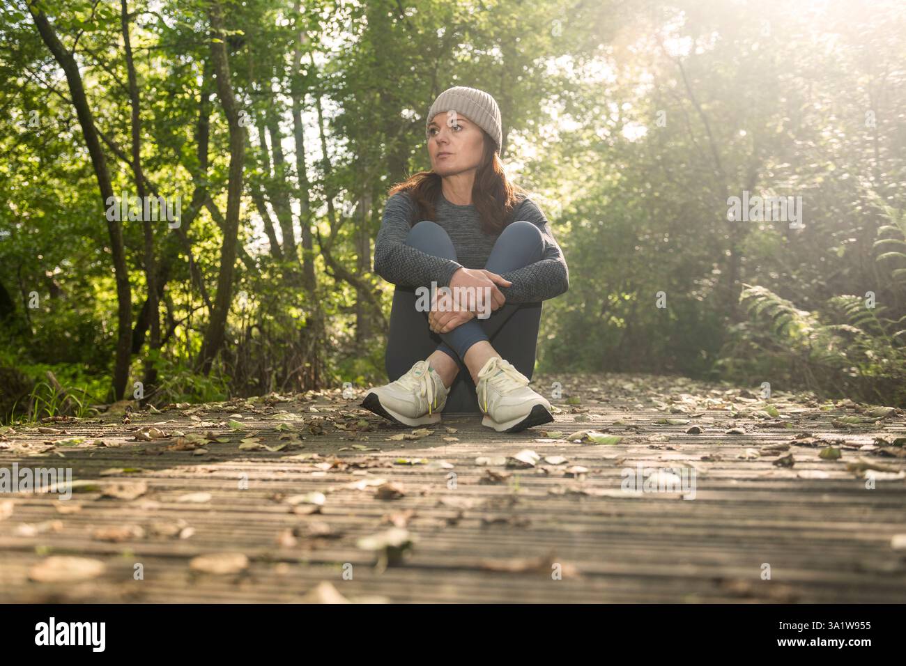 sporty woman sitting resting after exercise, outdoors boardwalk Stock ...