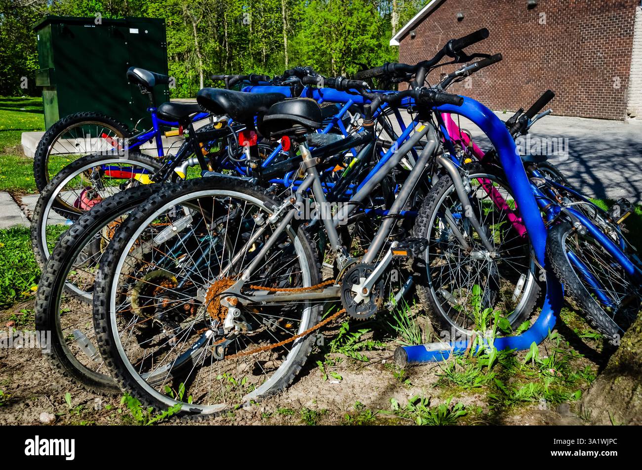 Right side view of crowded blue bike rack with deserted biycycles in ...