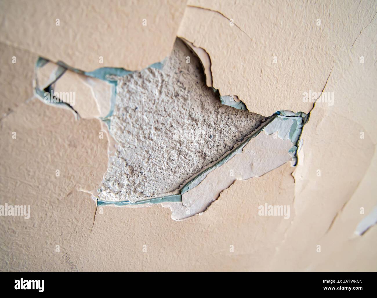 Multiple layers of different paint on an old wall, visible after a ...