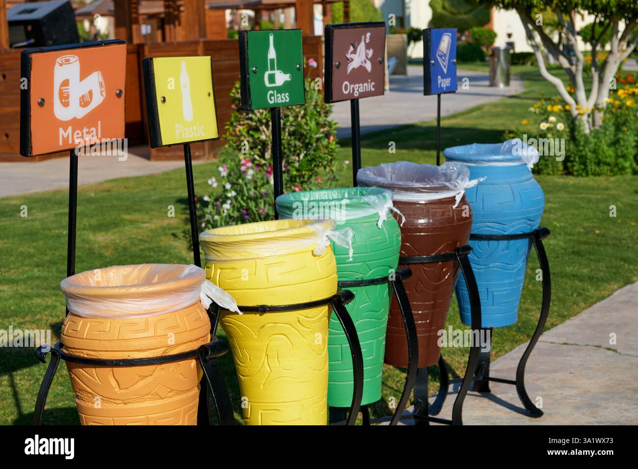 Colorful clay recycling bins on beach. Containers, trash bins for ...